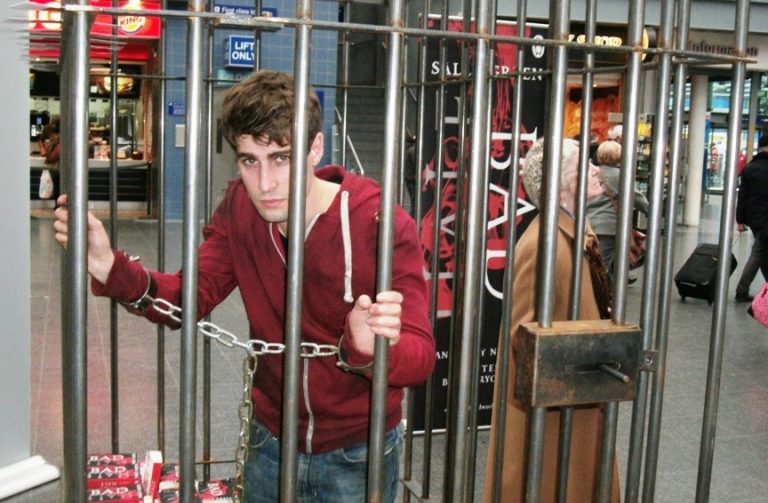Bemused commuters share Manchester Piccadilly Station with caged man to ...